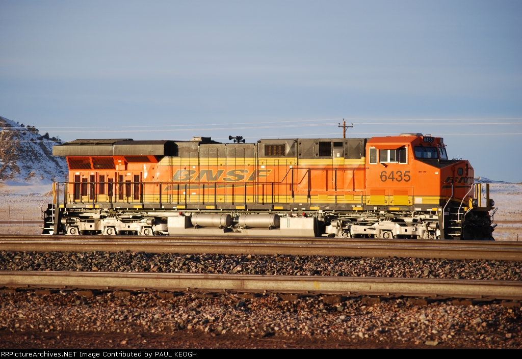BNSF 6435 sits on the ready line as the setting sun glistens off her Swoosh logo.
